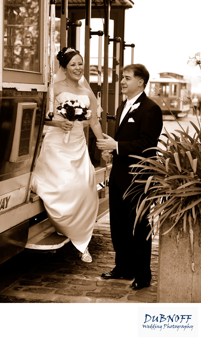 Newlywed Groom Assists Bride Stepping off a Cable Car in Sepia Tone