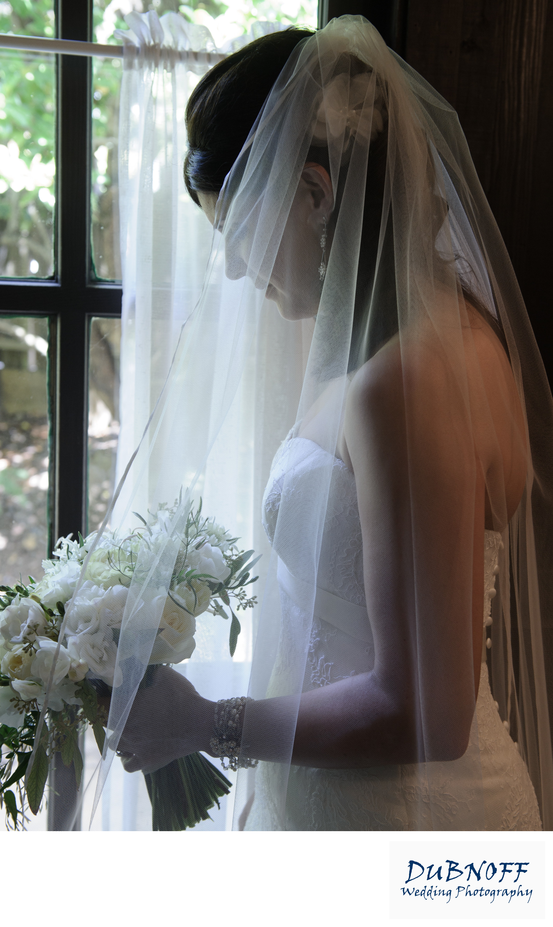 bride profile looking out the window with bouquet